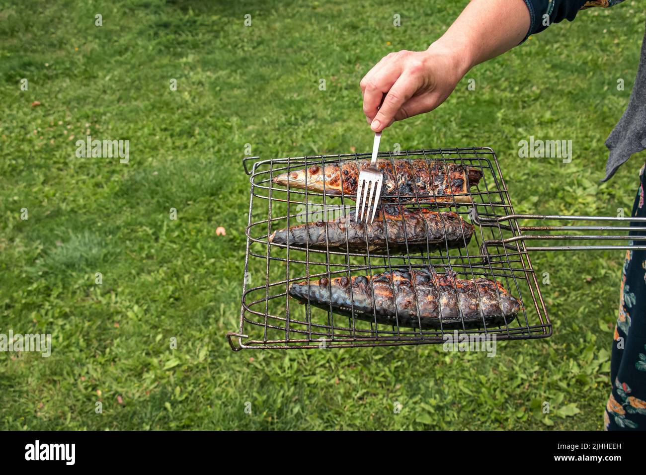 The process of cooking mackerel fish in a marinade on the grill. Fried ...