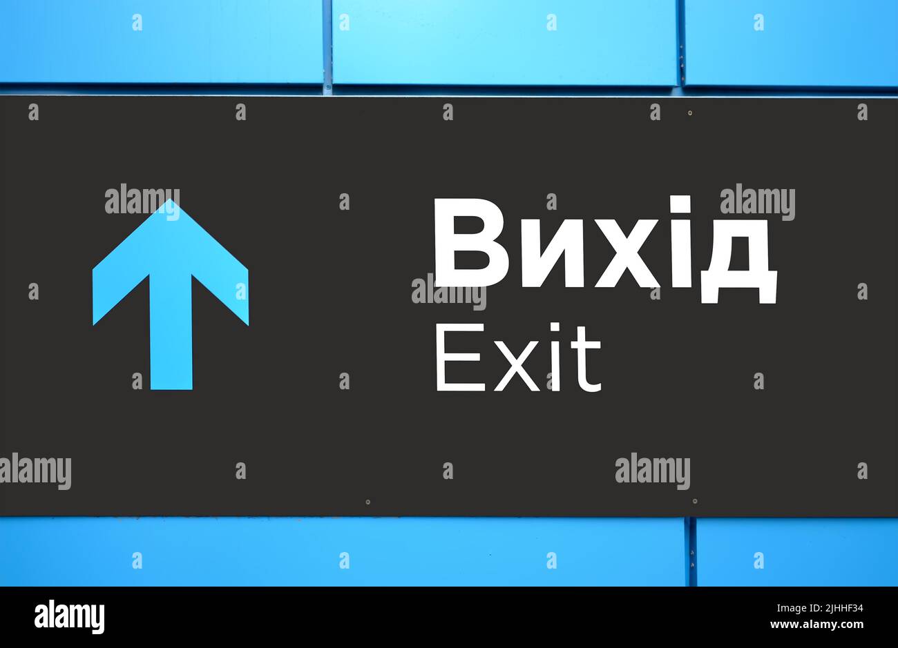 exit emergency sign on blue wall surface closeup, rescue evacuation ...