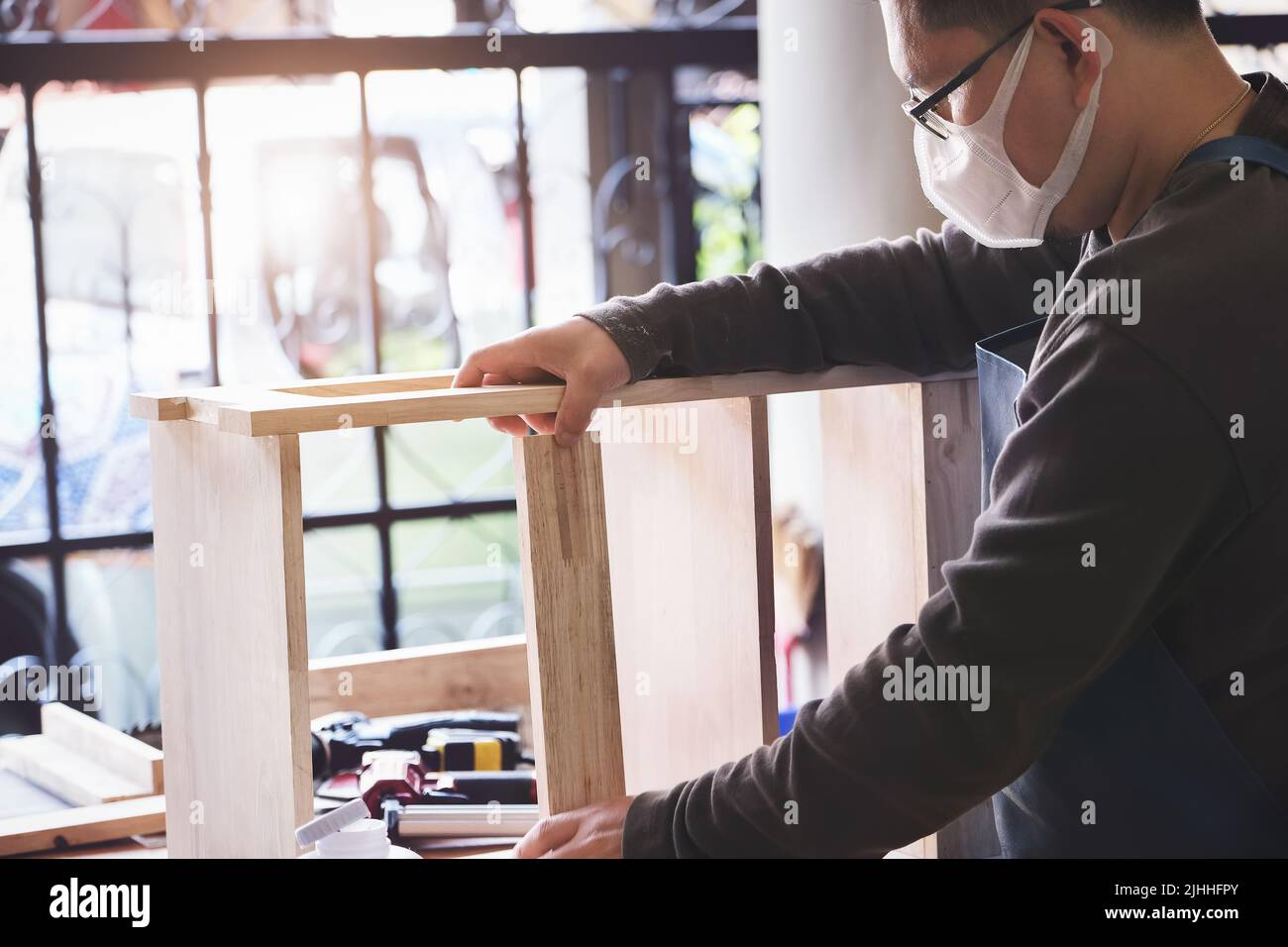 A carpenter measures the planks to assemble the parts, and build a ...