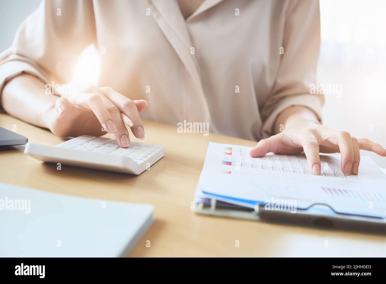 Business woman using calculator to review balance sheet annual using ...