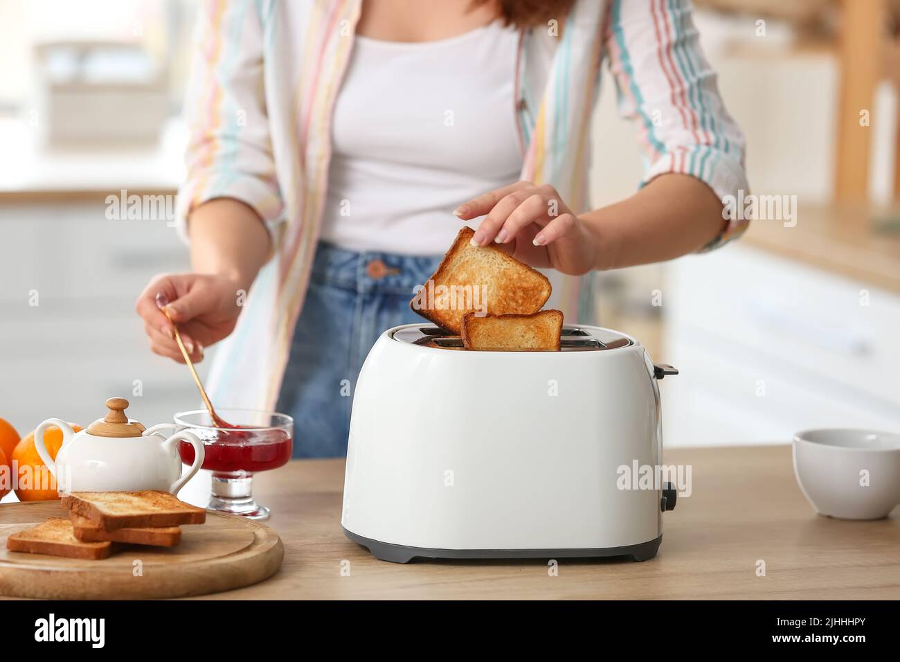 Beautiful young woman making tasty toasts in kitchen Stock Photo - Alamy