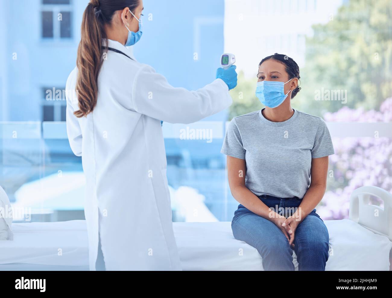 Doctor using thermometer to check the temperature of a patient ...