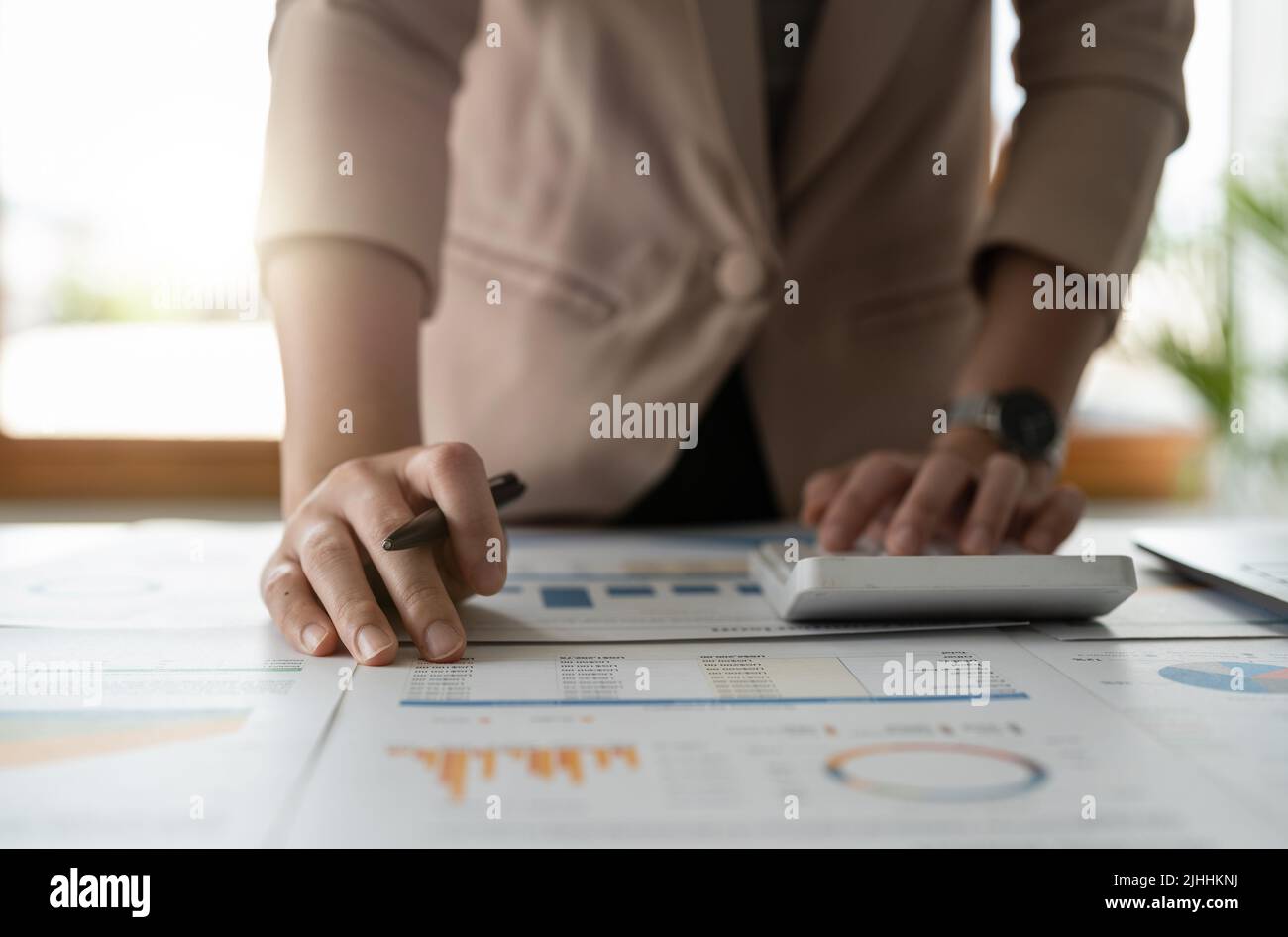 Close up of businesswoman or accountant hand holding pen working on ...