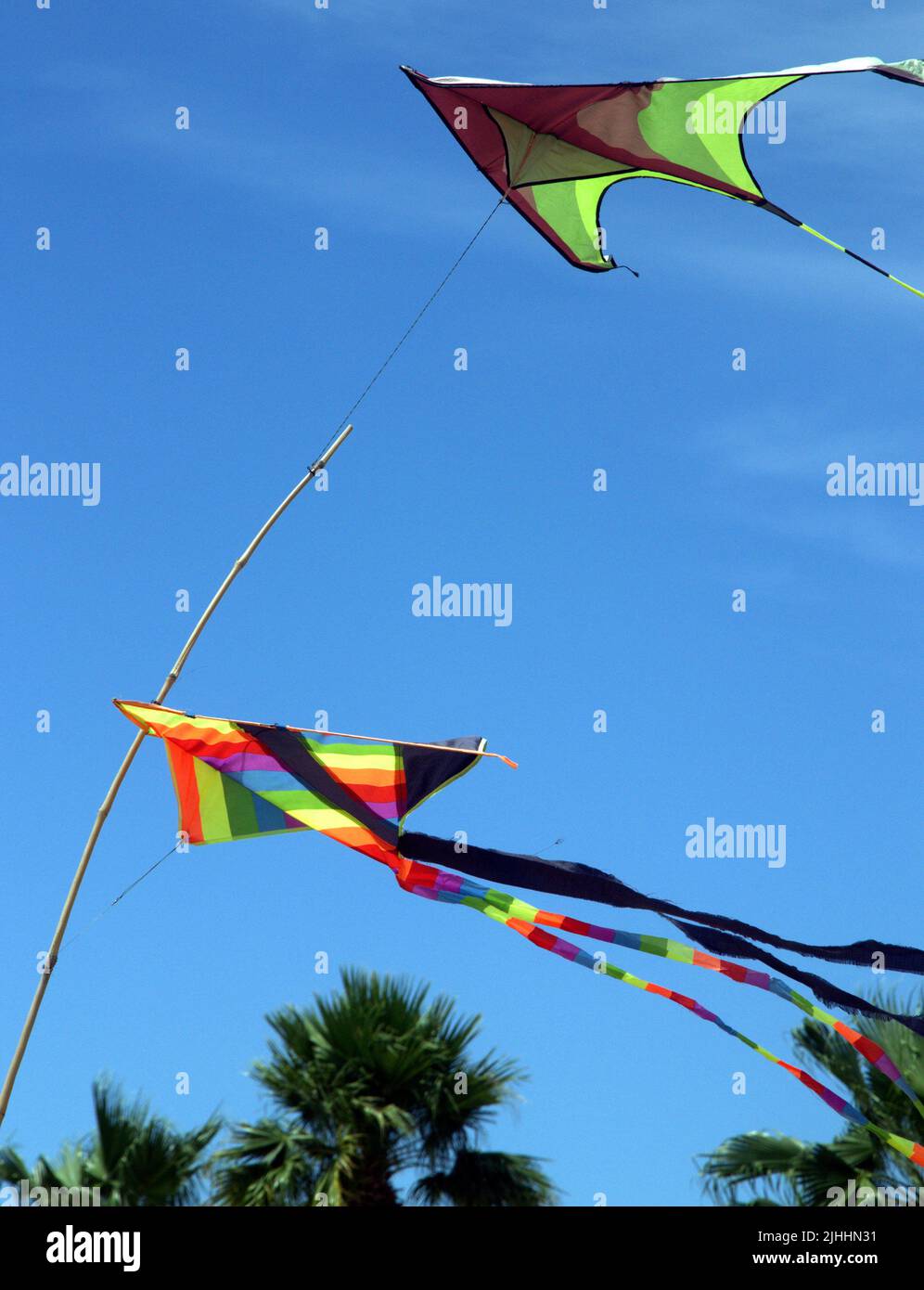 Kites flutter against a blue sky at the seaside resort of Pattaya ...