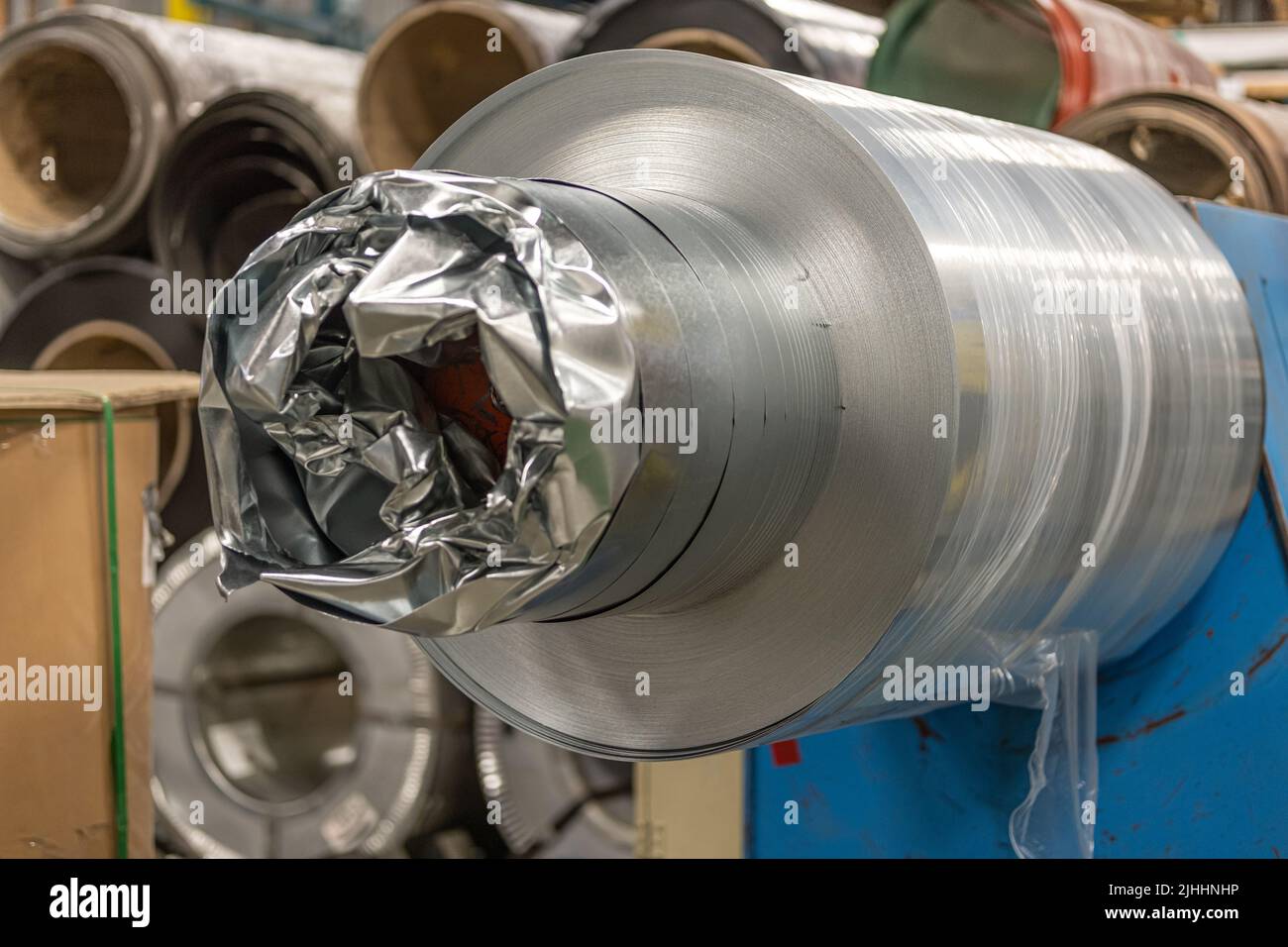 Damaged metal roll of coil on decoiling machine Stock Photo - Alamy