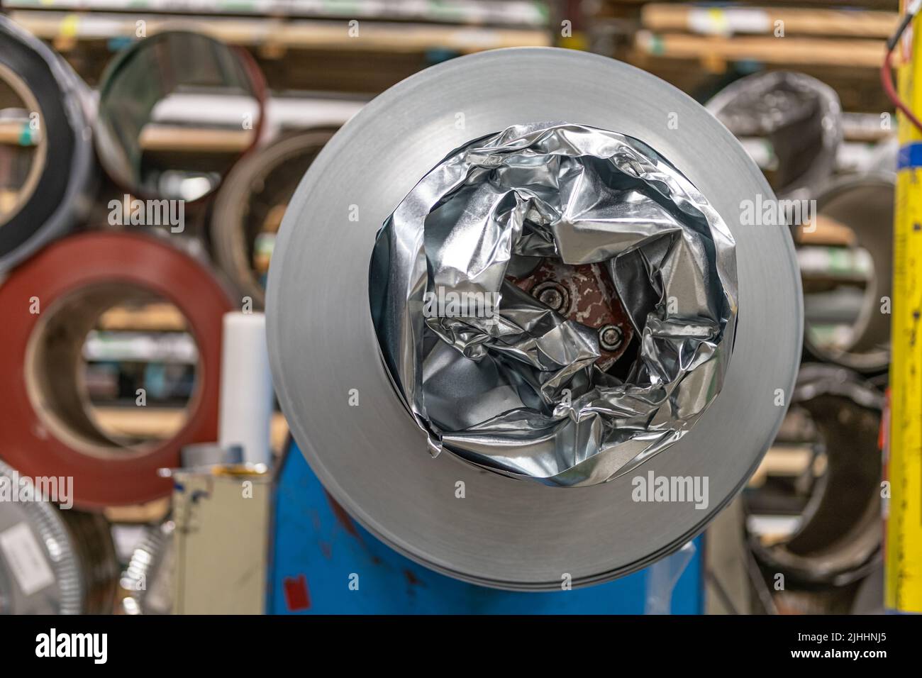 Damaged metal roll of coil on decoiling machine Stock Photo - Alamy