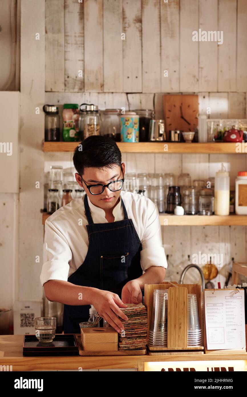 Coffeeshop barista checking in he has enough cup sleeves Stock Photo ...