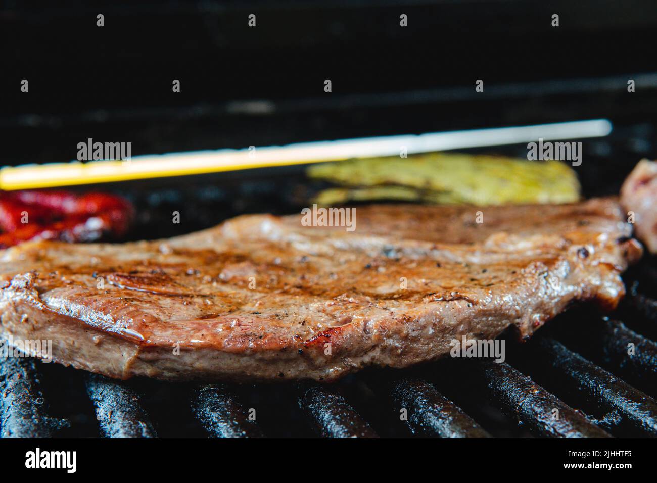 close up shot of a thin cut of top sirloin beef. Food on the grill, a ...