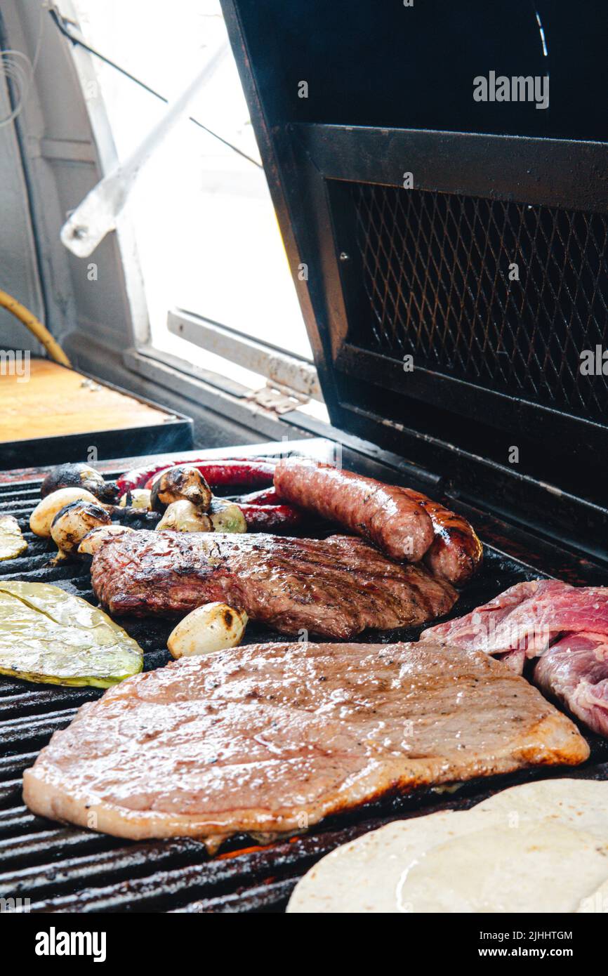 Grill is seen from the side with top sirloin cut and roasted nopales ...