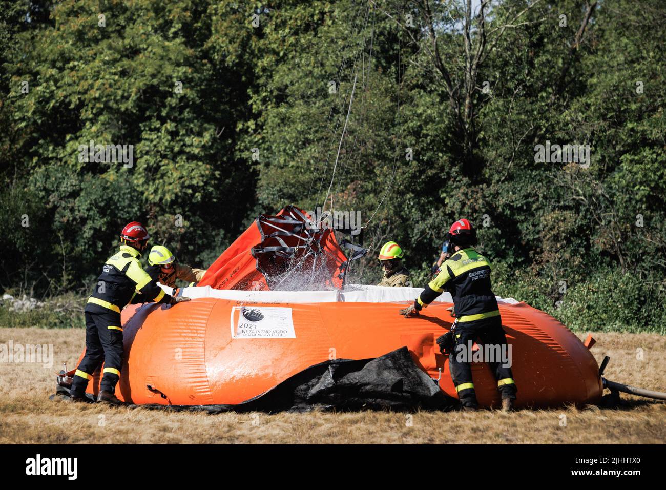 Firemen handle a bambi bucket for fighting wildfires as a Slovenian ...