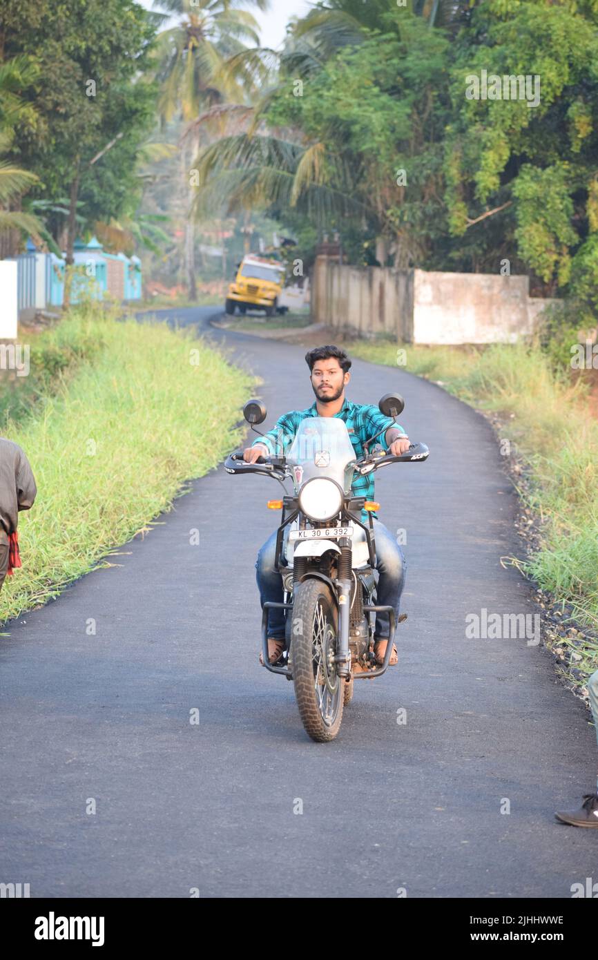 An indian young man riding a motorcycle near a paddy field Stock Photo ...