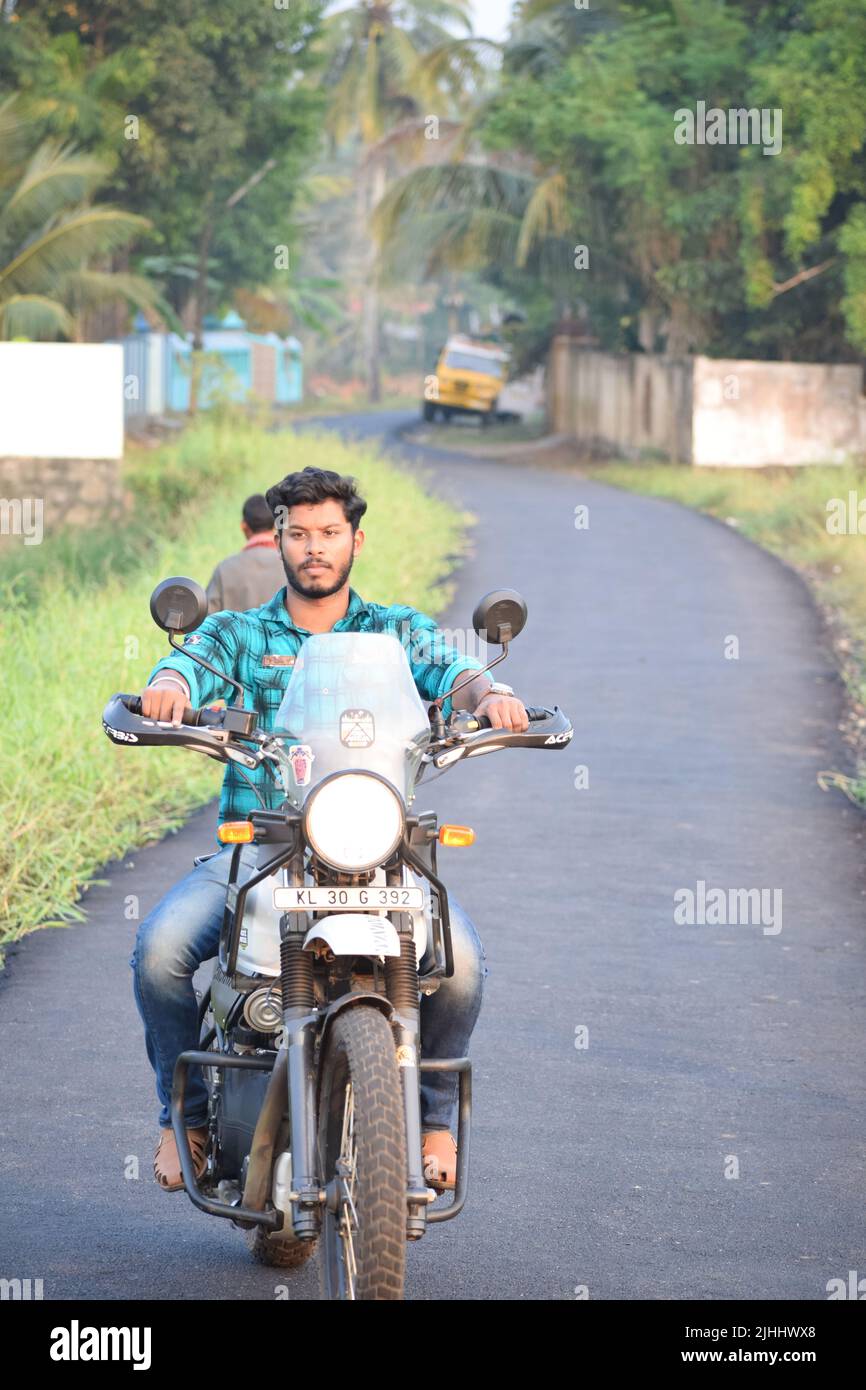 An indian young man riding a motorcycle near a paddy field Stock Photo ...