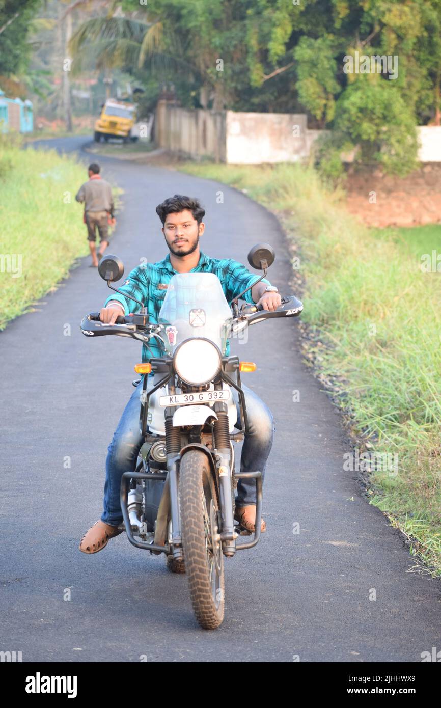 An indian young man riding a motorcycle near a paddy field Stock Photo ...