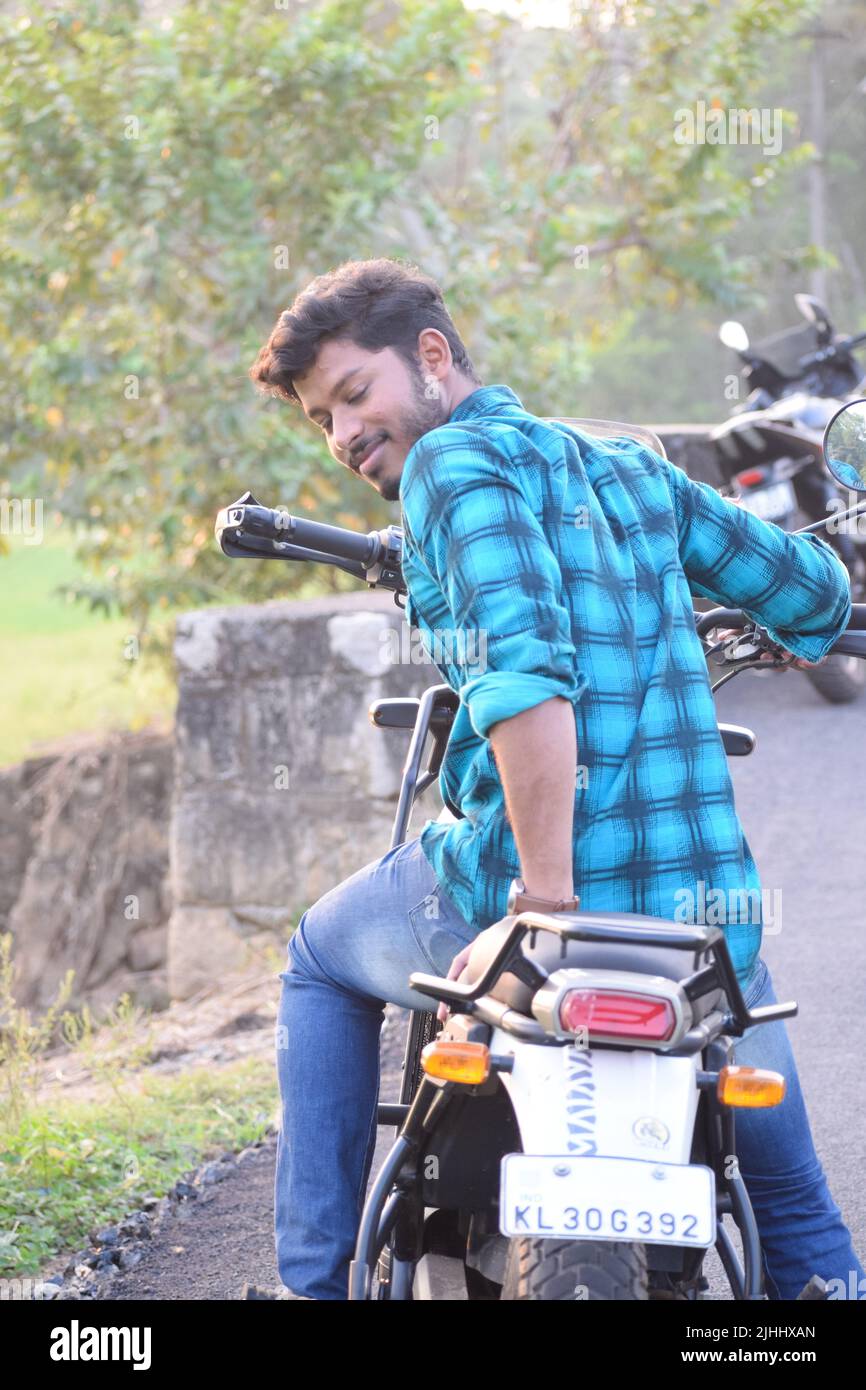 An Indian man sitting on a motorbike and posing for photo Stock Photo ...