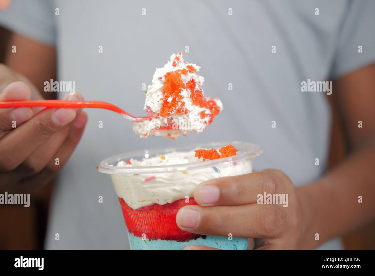 young men eating rainbow color cake Stock Photo - Alamy