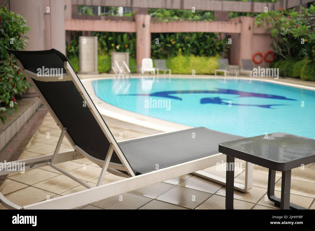 an empty chair and swimming pool Stock Photo - Alamy