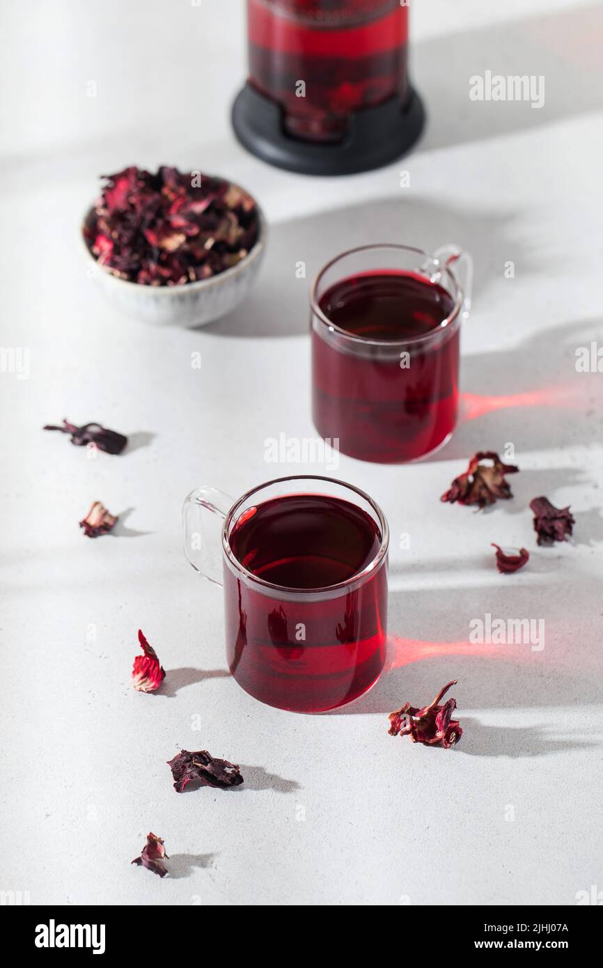 Herbal tea made from hibiscus petals in a transparent cup on a light ...