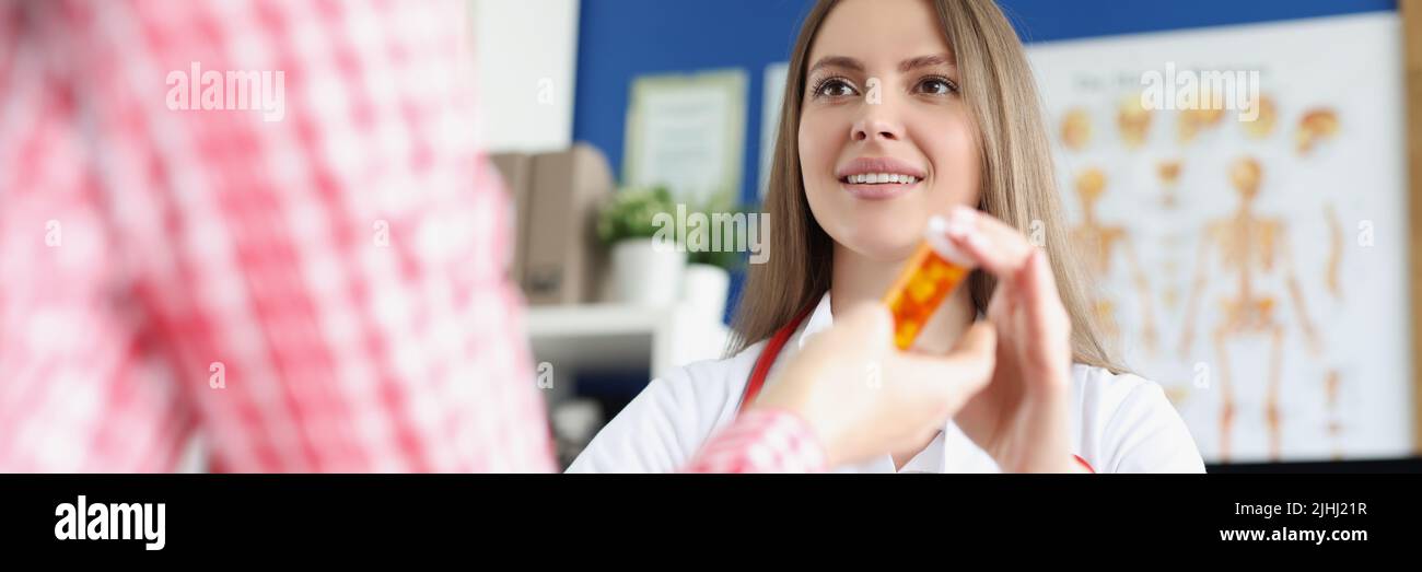 Qualified female doctor give medications in bottle to patient for ...