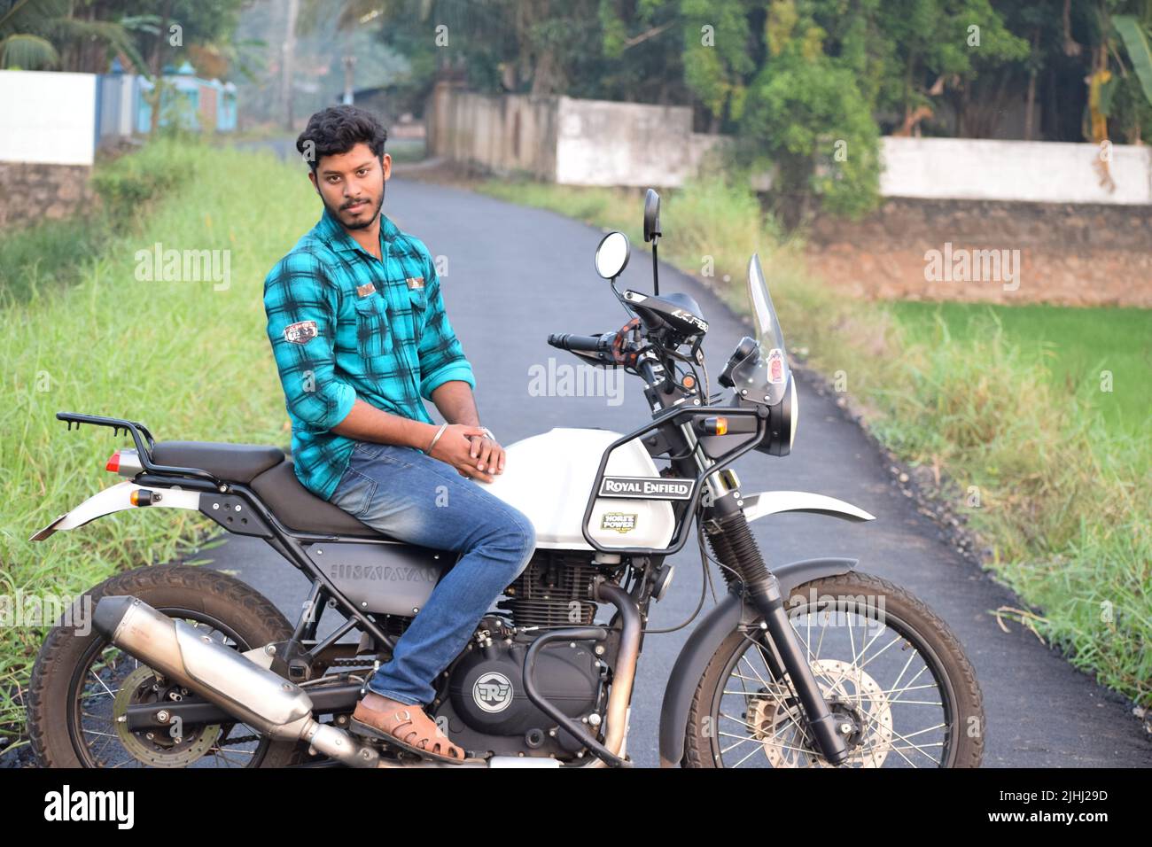 An indian young man riding a motorcycle near a paddy field Stock Photo ...