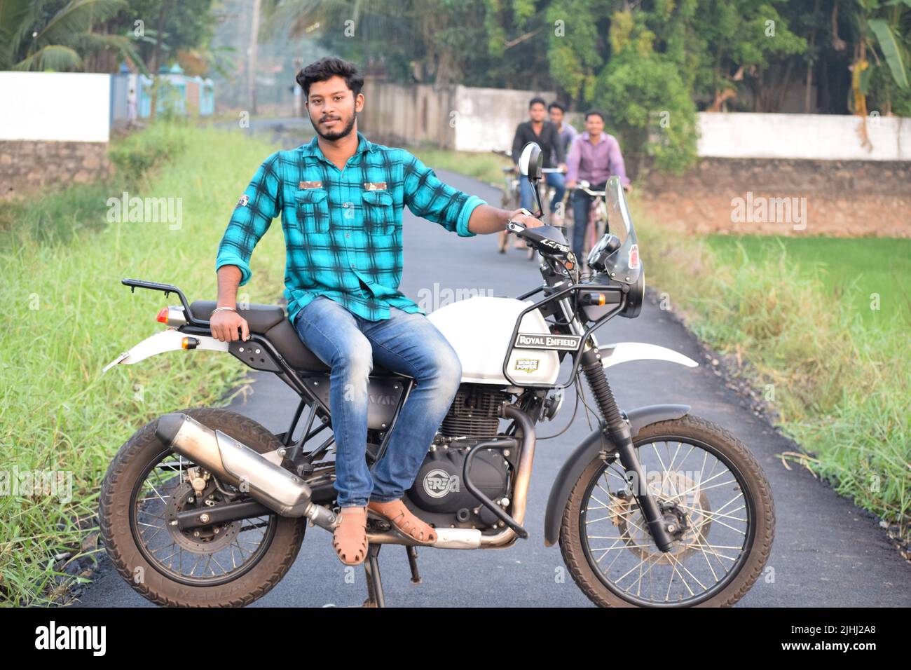 An indian young man riding a motorcycle near a paddy field Stock Photo ...