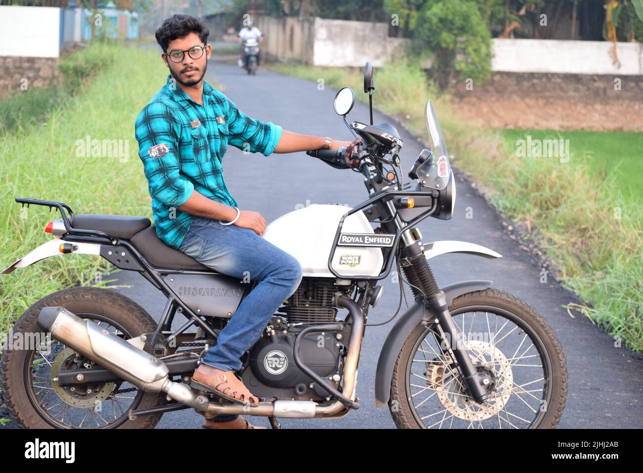 An indian young man riding a motorcycle near a paddy field Stock Photo ...