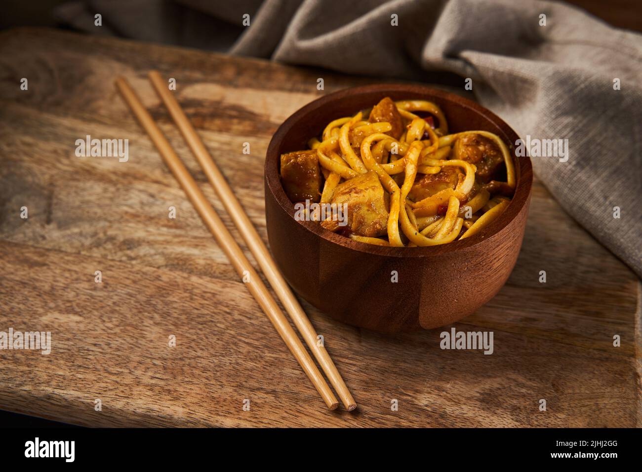 Bami Goreng, Indonesian pasta dish speciality in a wooden bowl with ...