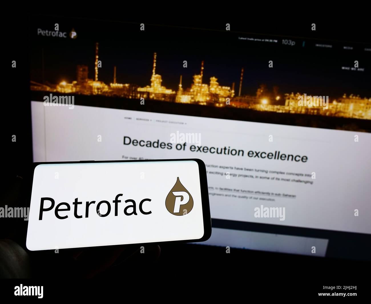 Person holding cellphone with logo of British energy services company Petrofac Limited on screen ...