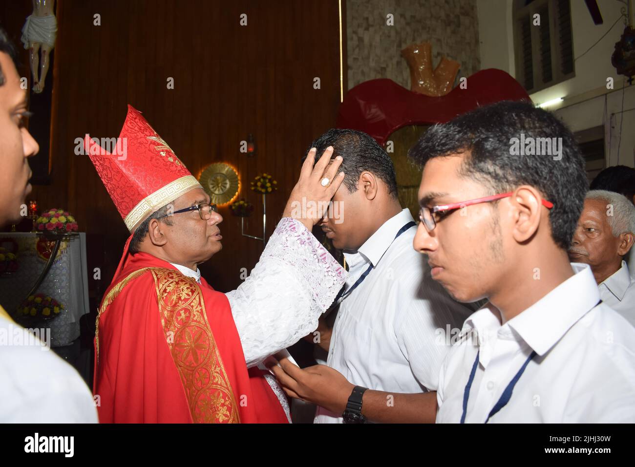 Catholic bishop is giving Confirmation sacrament Stock Photo - Alamy