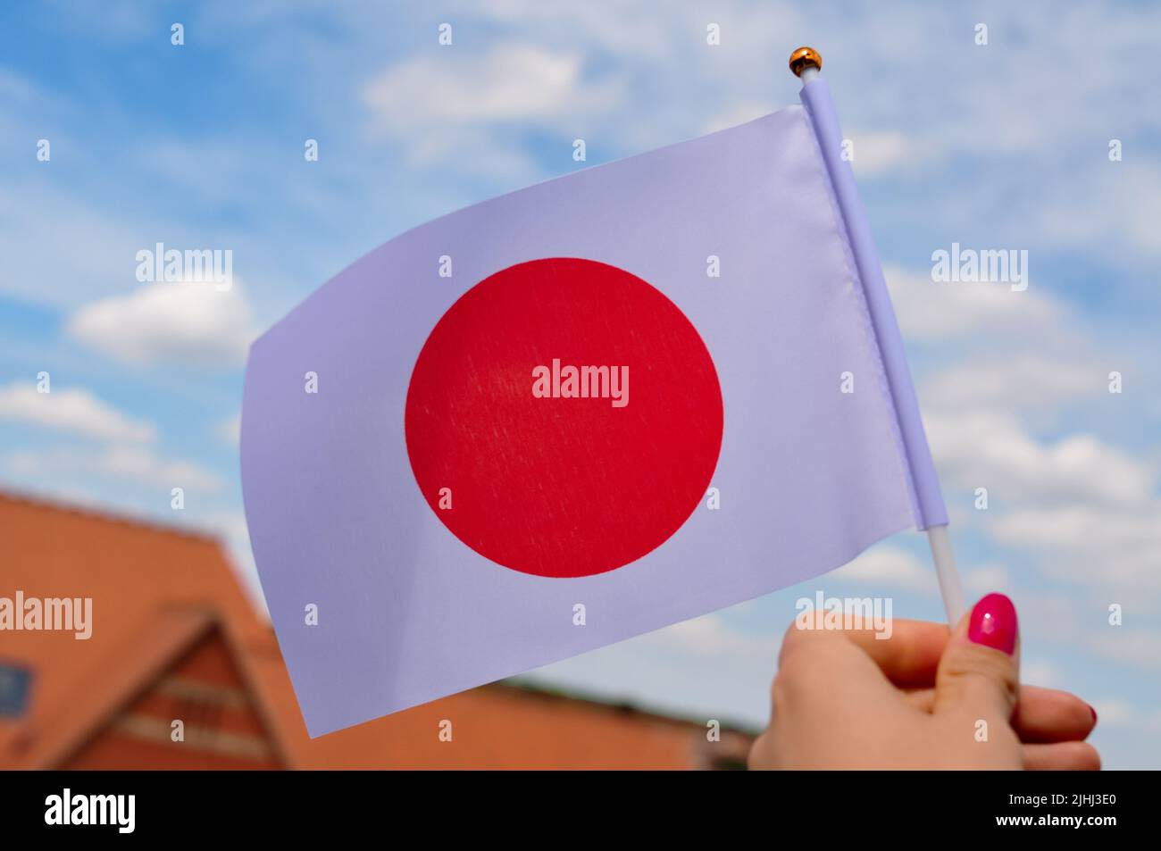 the national white flag with red circle of Japan in hand close up Stock ...