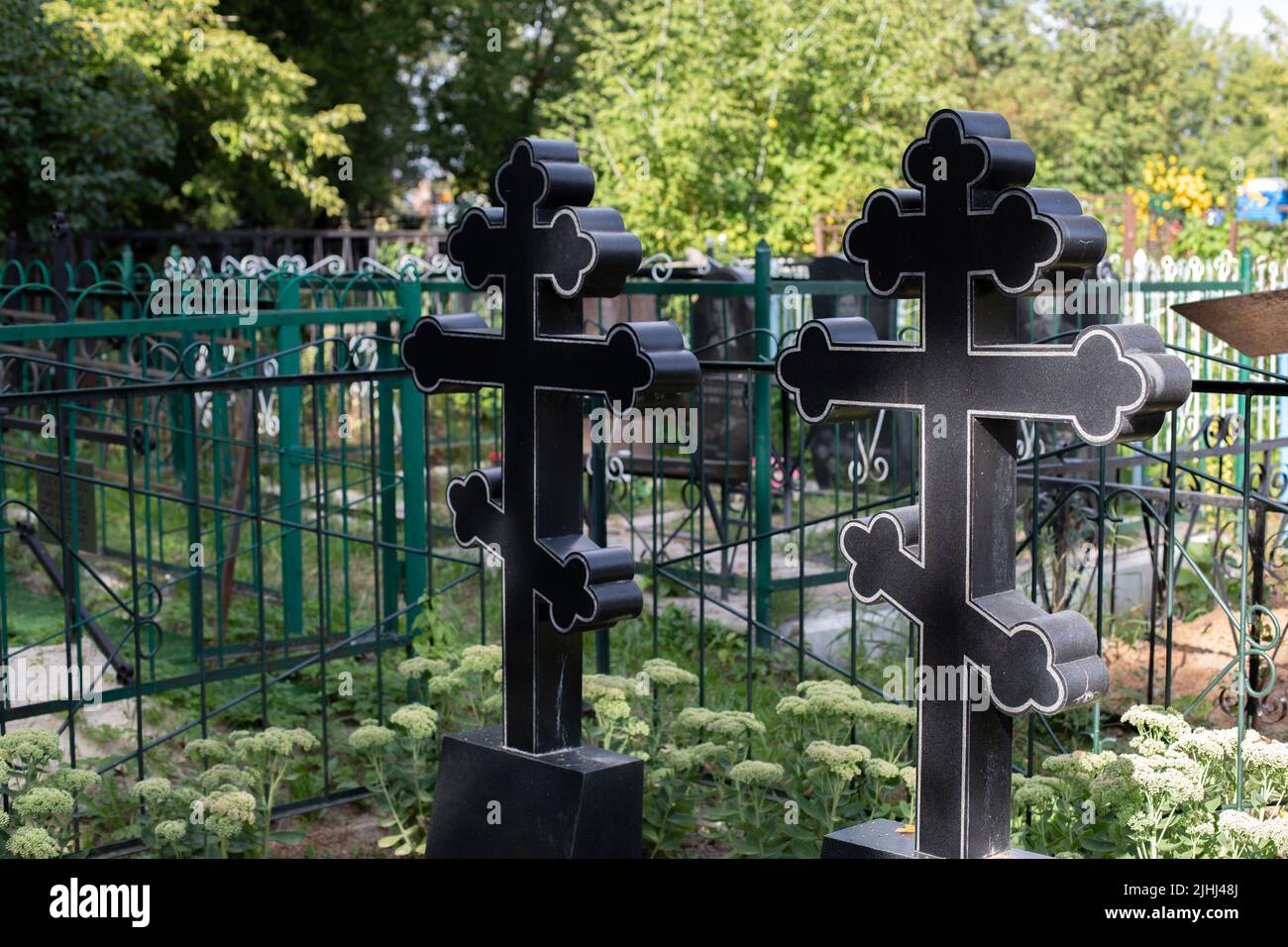 Two black stone crosses in a Christian cemetery, death grave religious ...