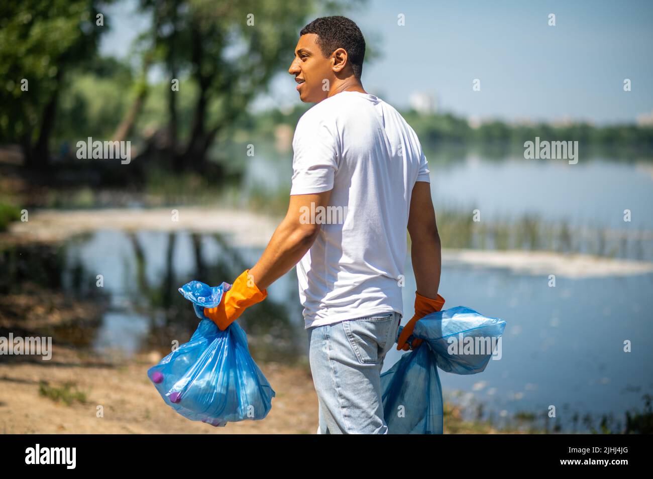 Side and back view of guy with garbage bags Stock Photo - Alamy