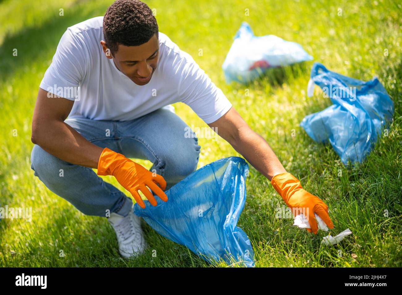 Top view of guy collecting garbage in bag Stock Photo - Alamy