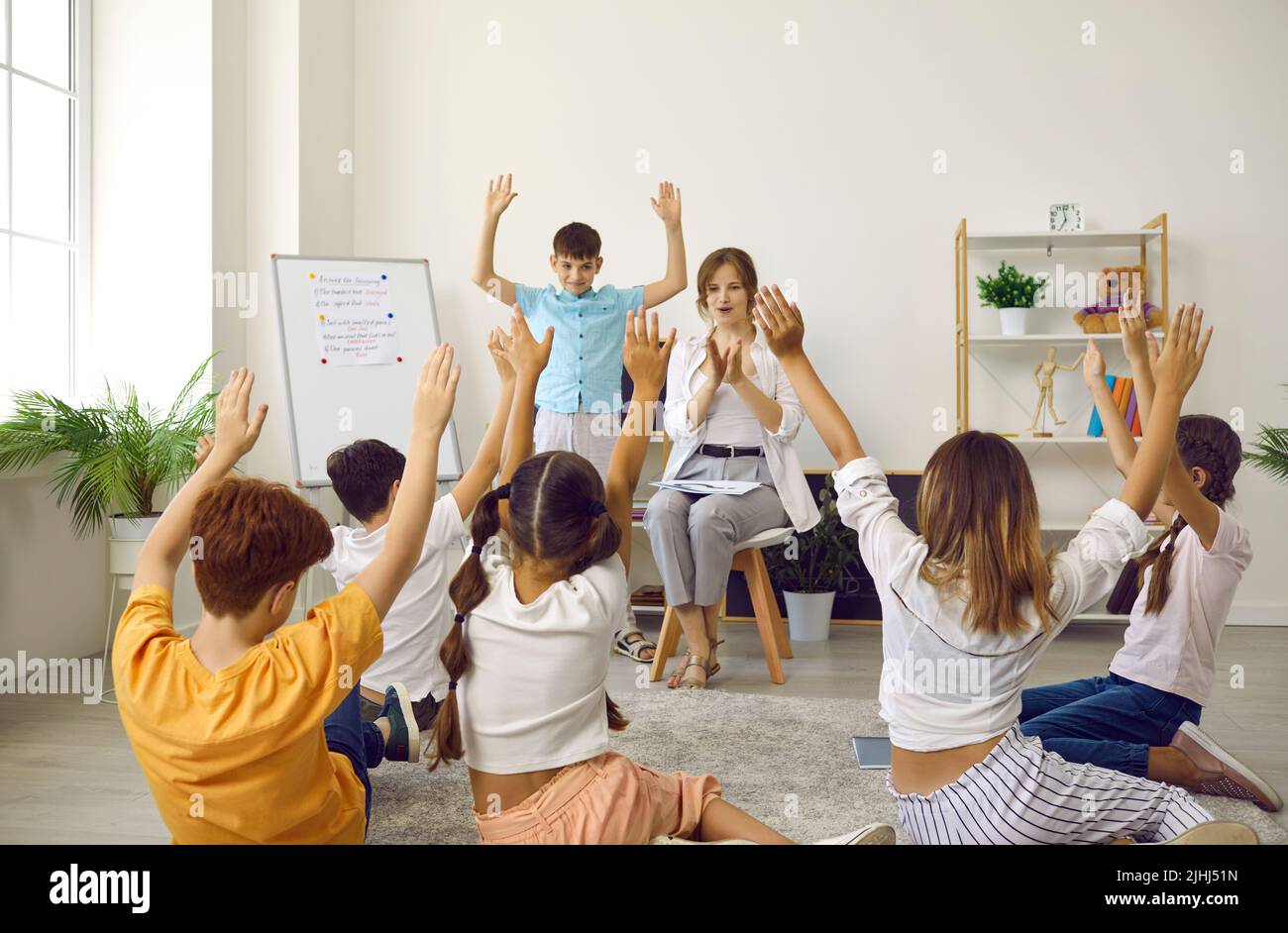 Happy school students with teacher playing games and having fun in the ...