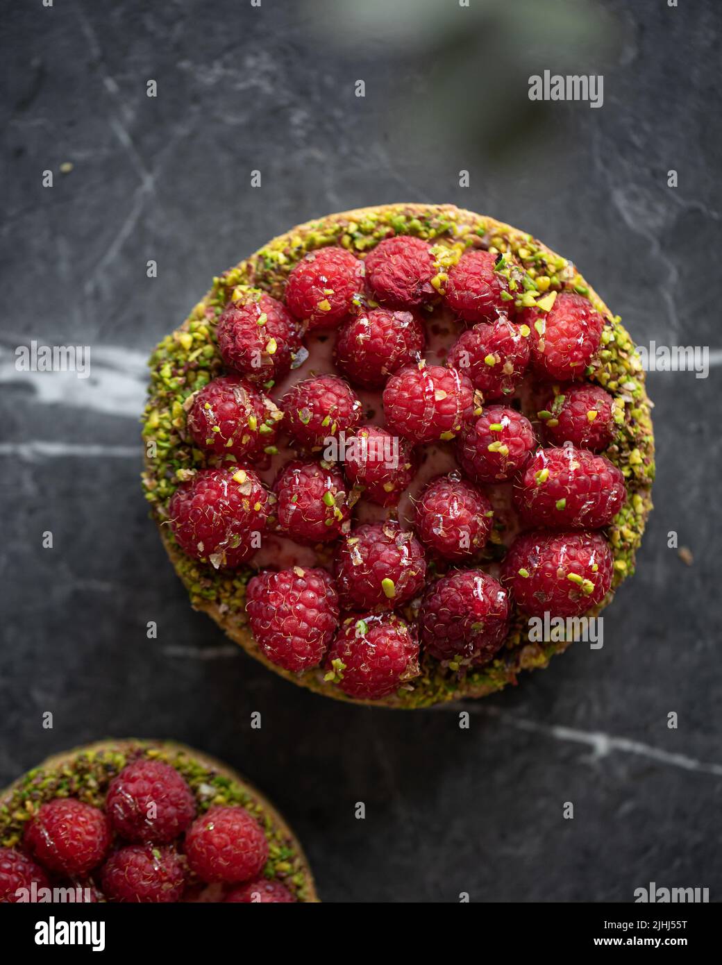 Two delicious raspberry tartlets with pistachios Stock Photo - Alamy