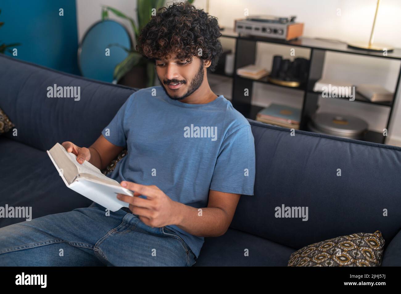 Curly young guy reading book hi-res stock photography and images - Alamy