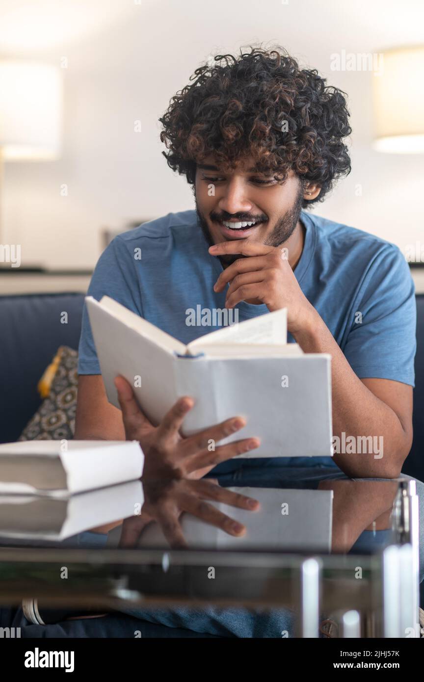 Curly young guy reading book hi-res stock photography and images - Alamy