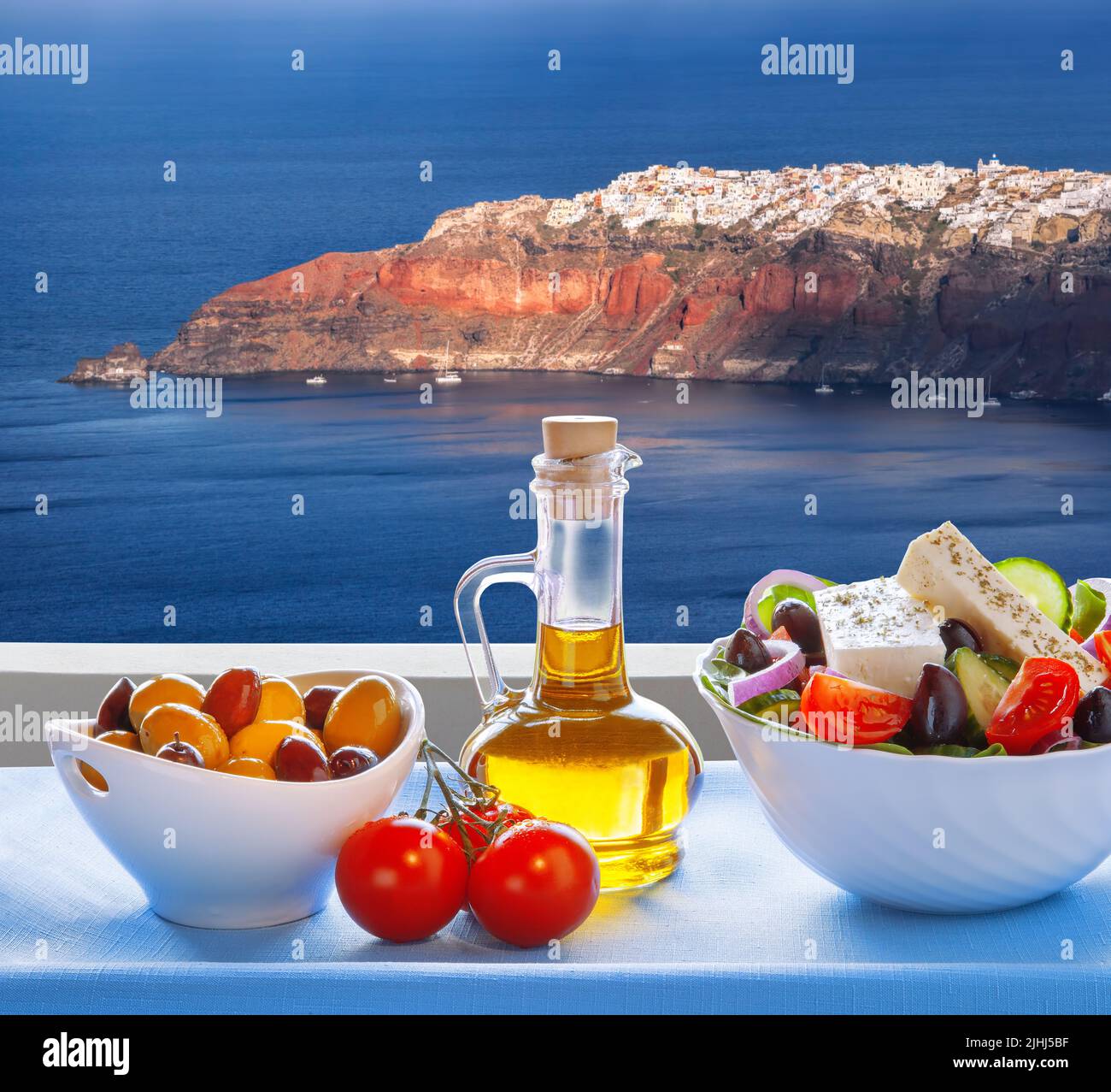 Greek salad against famous Oia village, Santorini island in Greece ...