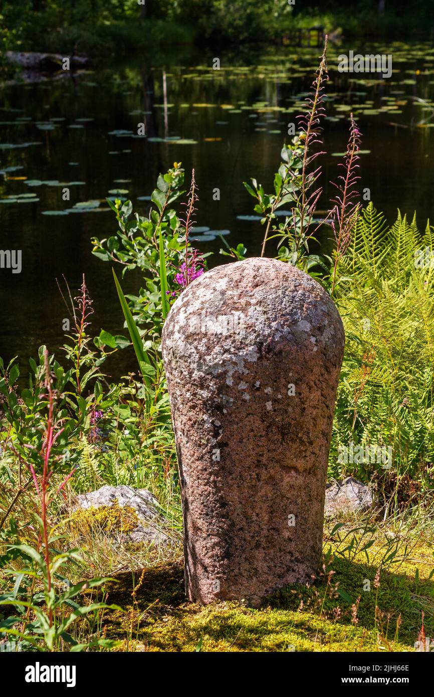 Old stone bollar at a canal with wildflower Stock Photo - Alamy