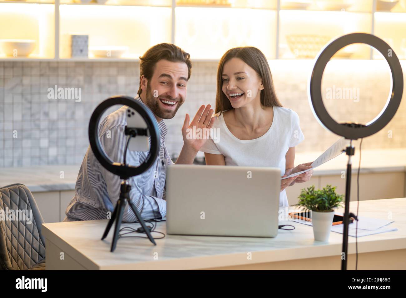 Two colleagues having a video conference online and looking excited ...