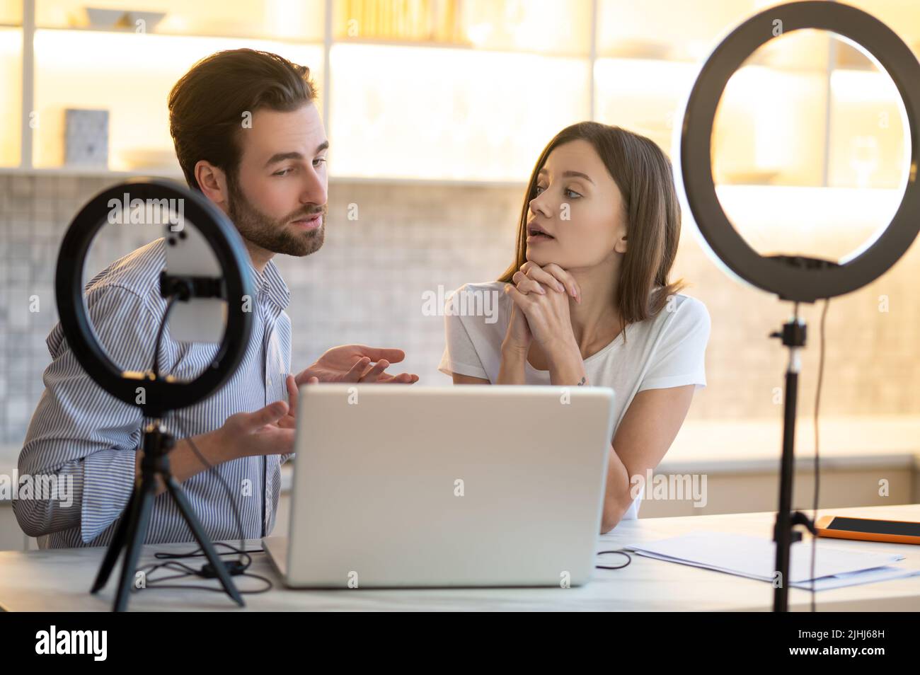 Two vloggers having online tutorial and looking involved Stock Photo ...