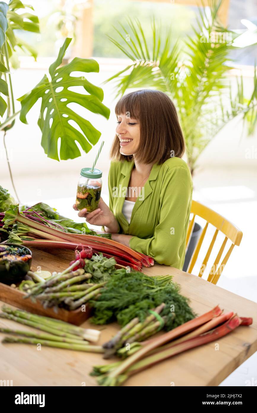 Woman with lots of fresh food ingredients indoors Stock Photo - Alamy