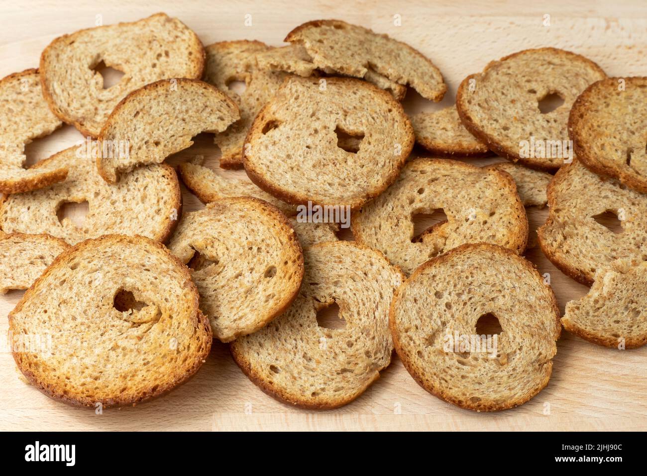 Mini rolls of baked bread on wooden background. Bread chips Stock Photo ...