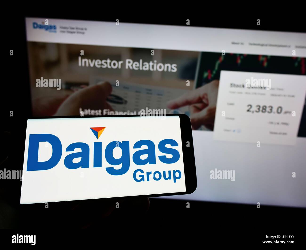 Person holding mobile phone with logo of Japanese energy company Daigas Group (Osaka Gas) on ...