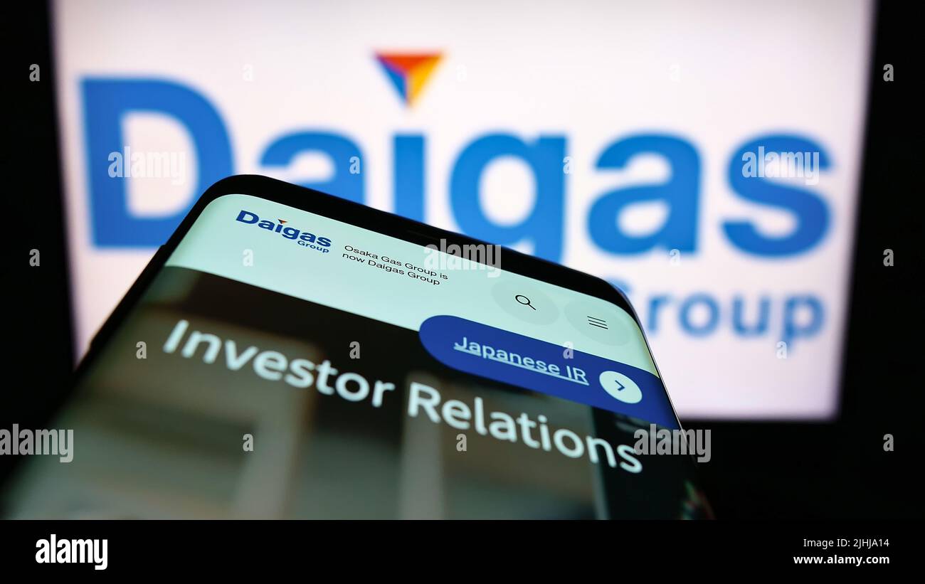 Mobile phone with webpage of Japanese energy company Daigas Group (Osaka Gas) on screen in front ...