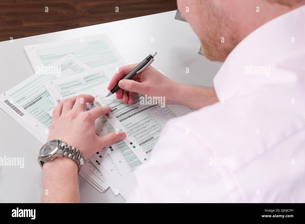 young man works hard at his tax declaration on his desk Stock Photo - Alamy