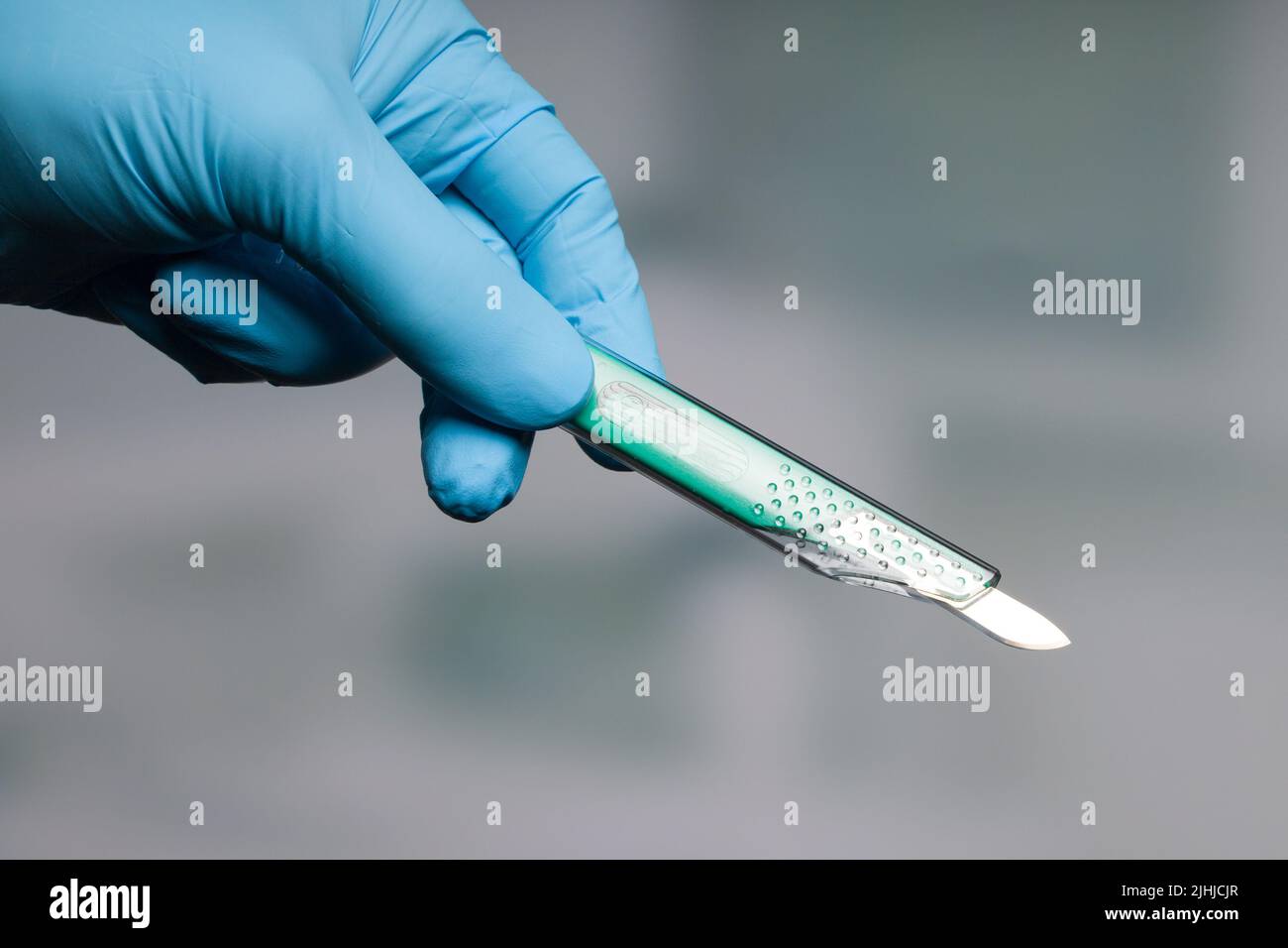 Doctor's hand with a new disposable scalpel Stock Photo - Alamy