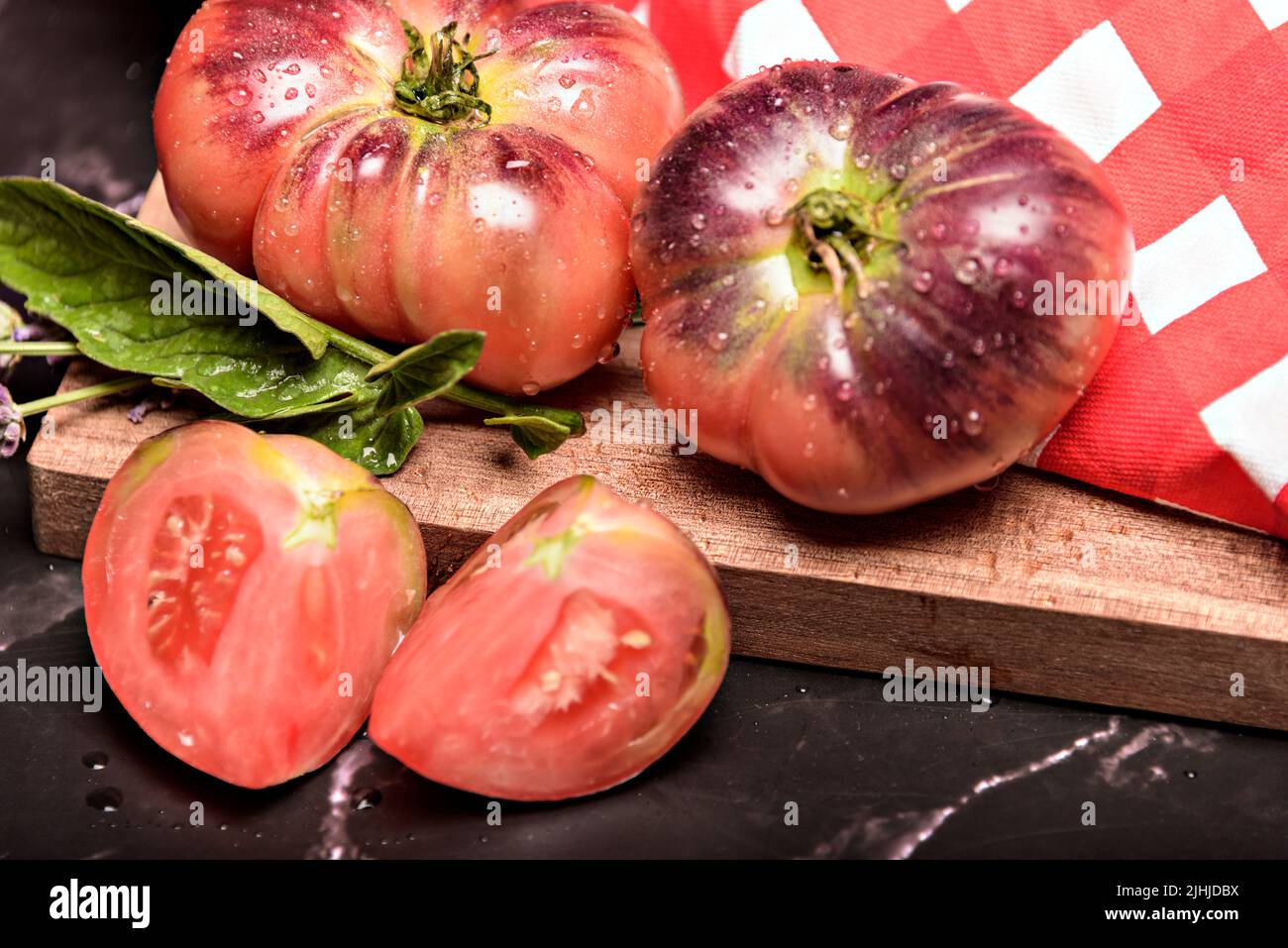 Still life tiger tomatoes dark background Stock Photo - Alamy