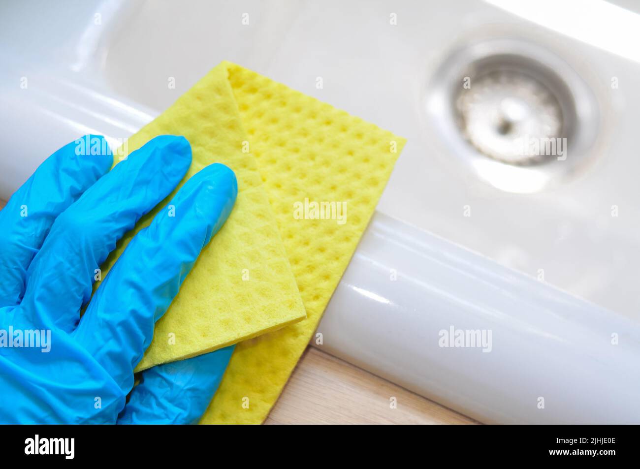 close up of hand in blue gloves with yellow rag for wiping mud,cleaning ...