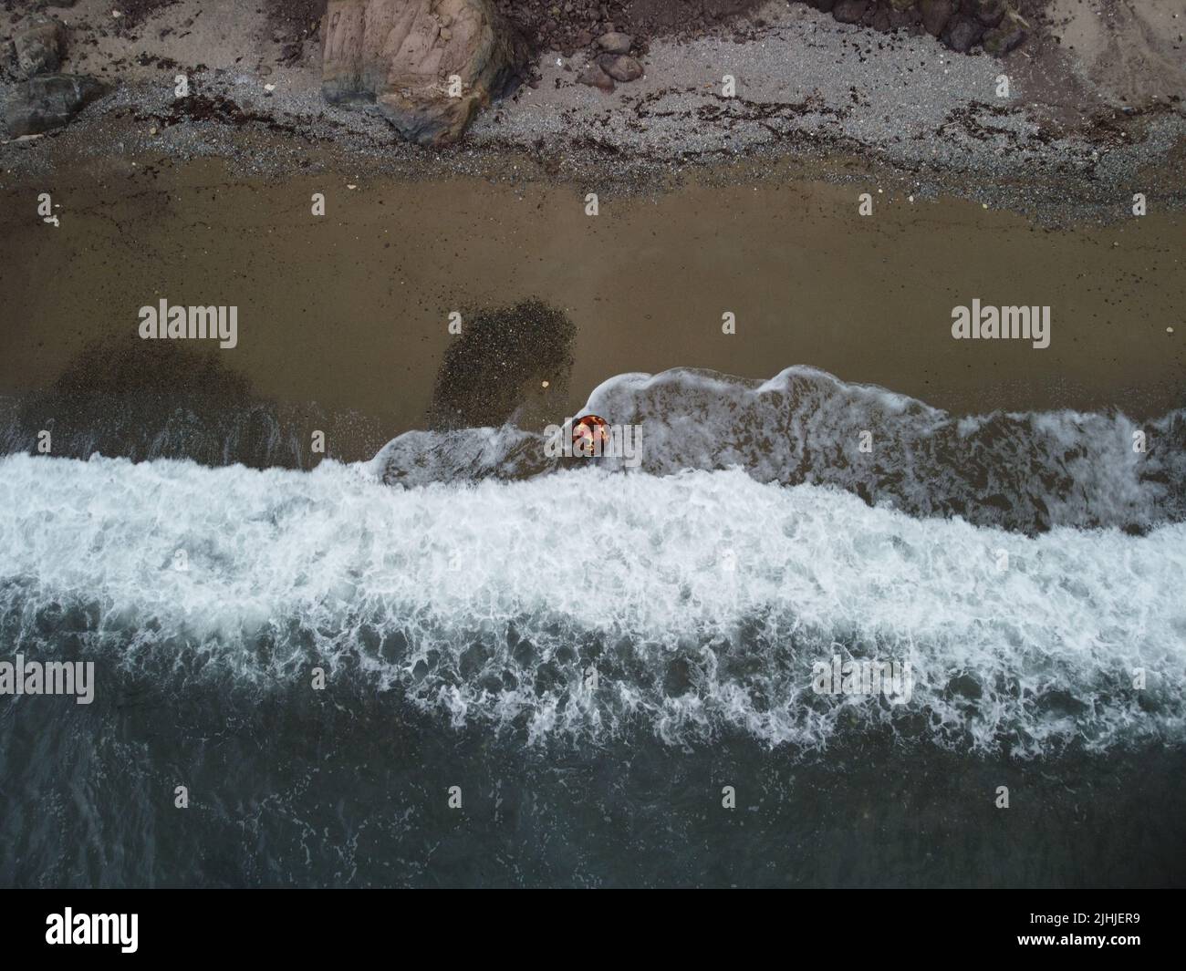 Aerial view from above on old rusty floating marine mine on the beach ...
