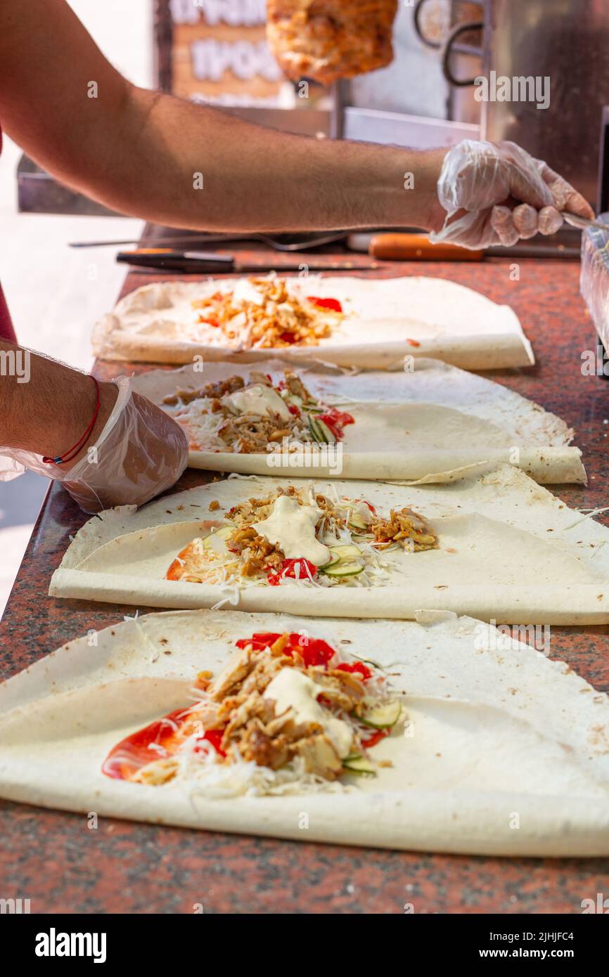 Hands of a professional chef who makes Shawarma in an arabian ...